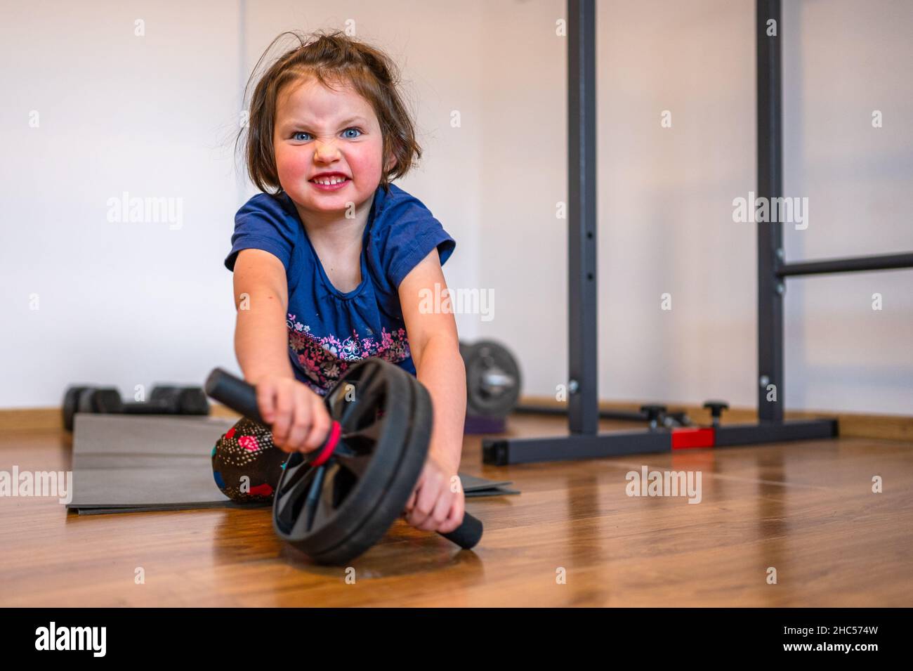 A four-year-old girl is doing calisthenics workout in home gym Stock ...