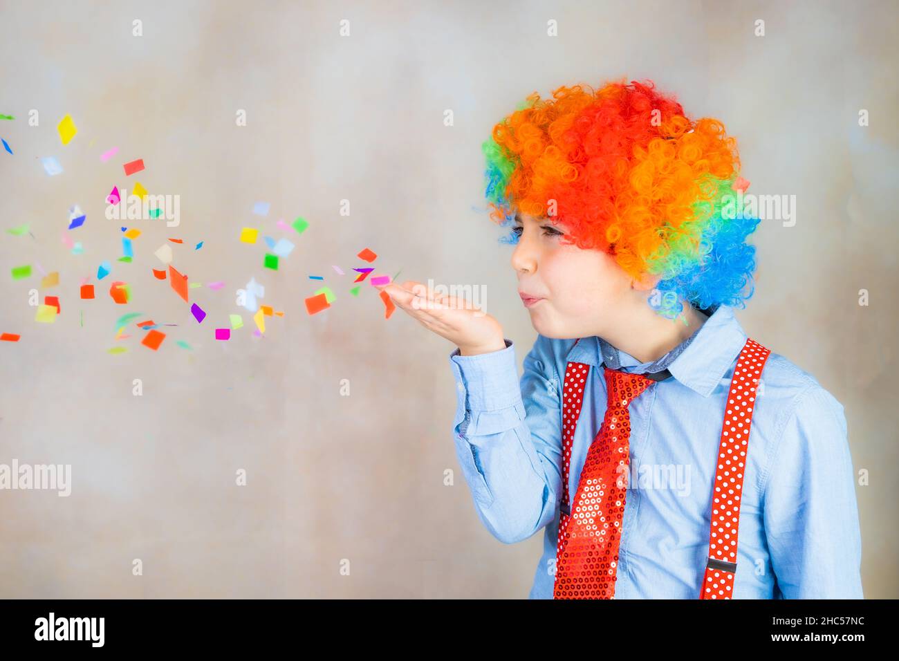 Funny boy blowing confetti at carnival Stock Photo - Alamy