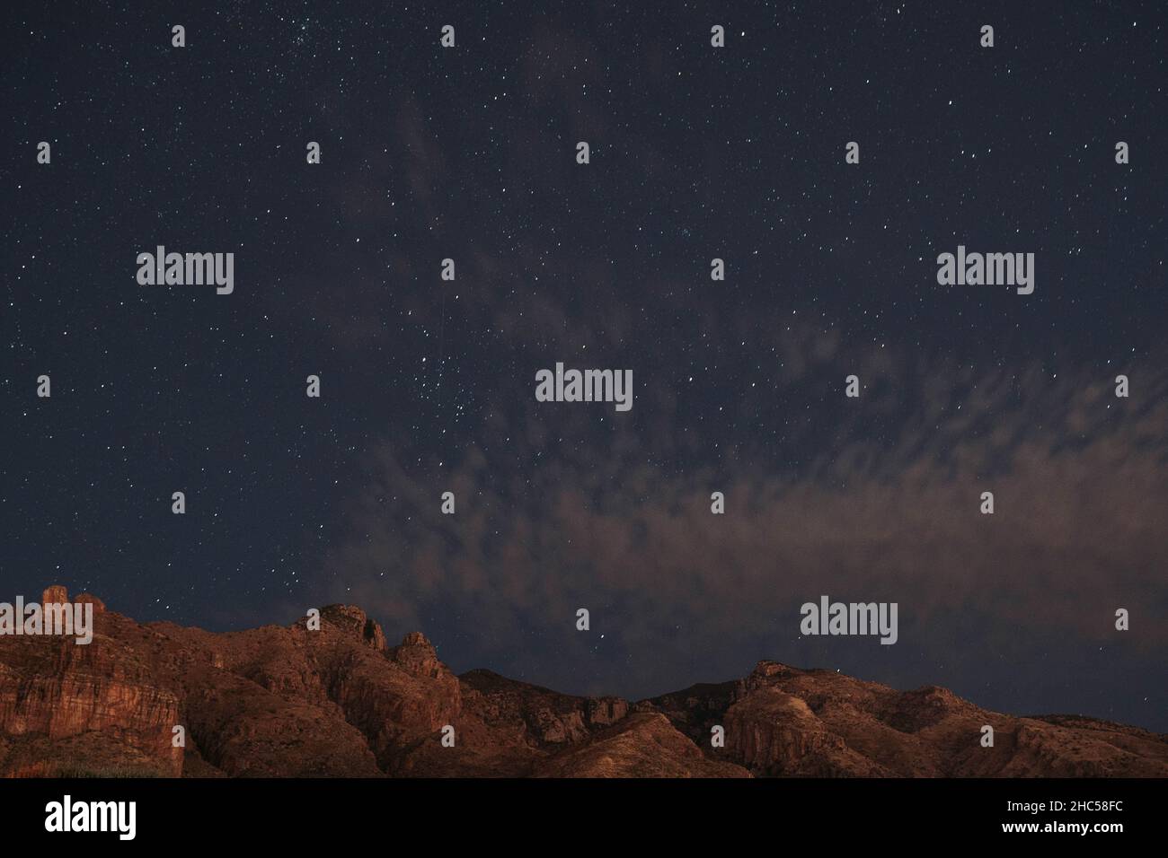Beautiful view of the cloudy night sky with stars over a landscape with ...