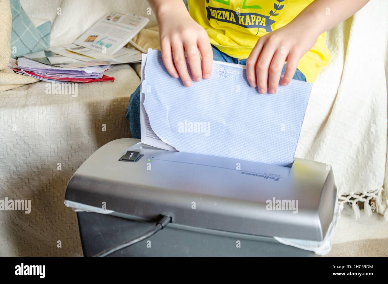 A child pushes wast paper into a shredder Stock Photo - Alamy