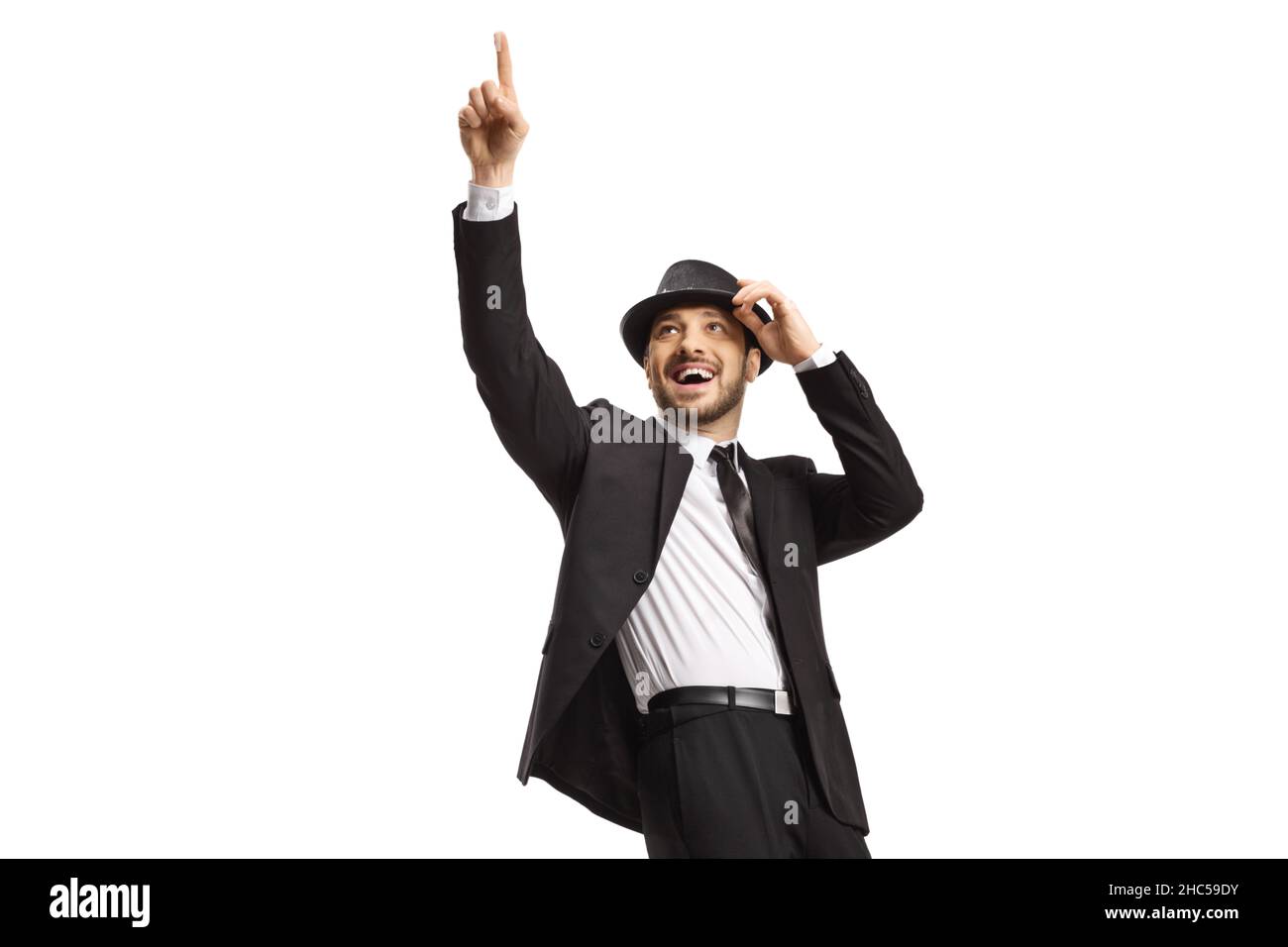 Man in a black suit and hat pointing up isolated on white background ...