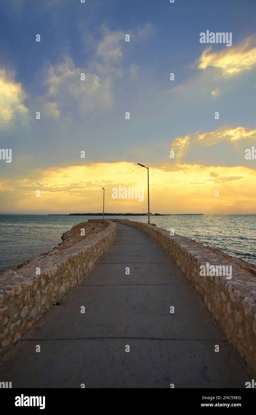 Vertical shot of a dock by the sea at sunset Stock Photo - Alamy