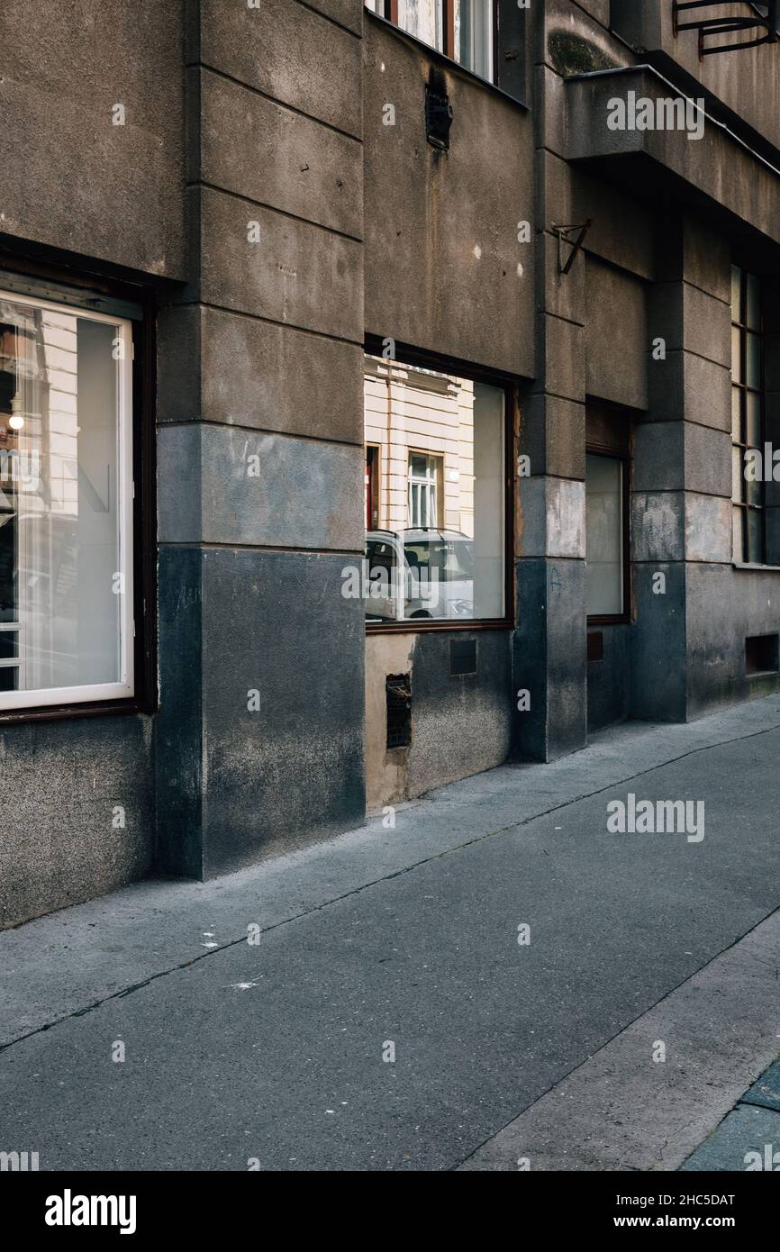 Vertical shot of a building with showcase windows reflecting cars on ...
