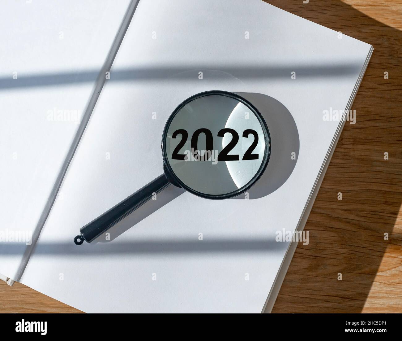 2022 year through magnifying glass on book with empty new page. Start ...