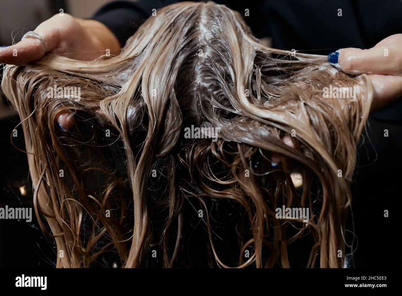 Hairdresser in beauty salon washes his client hair, before procedure of ...