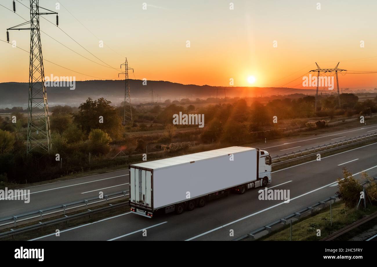 White Transportation truck along the highway in dreamy sunset. Highway ...