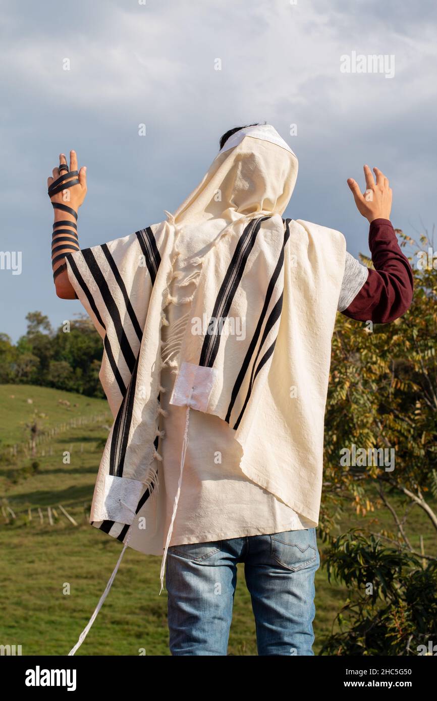 Vertical photo of Juido Latino covering his head wearing talit and ...