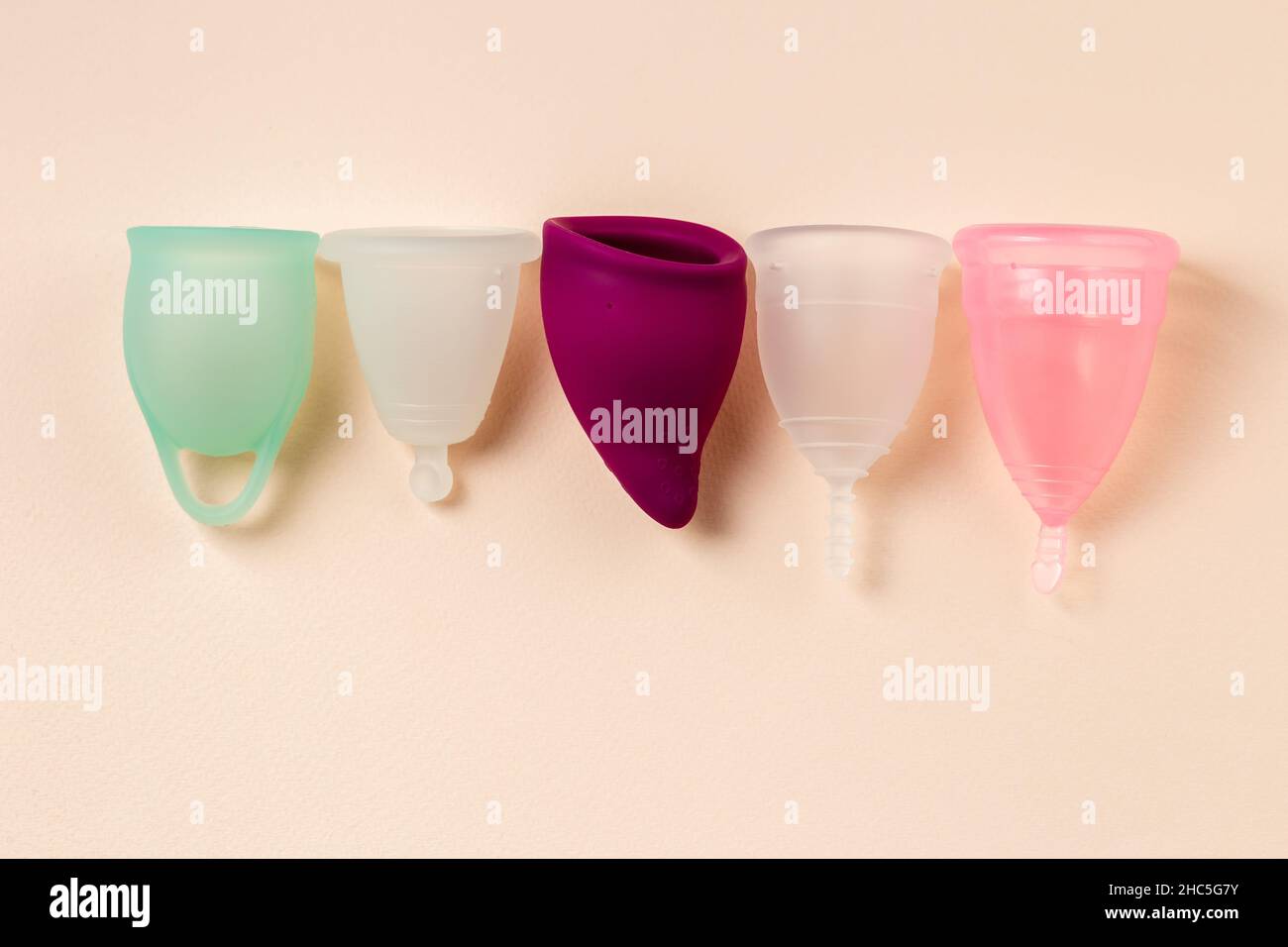 Five menstrual cups of different size, shapes and colors in a row on ...
