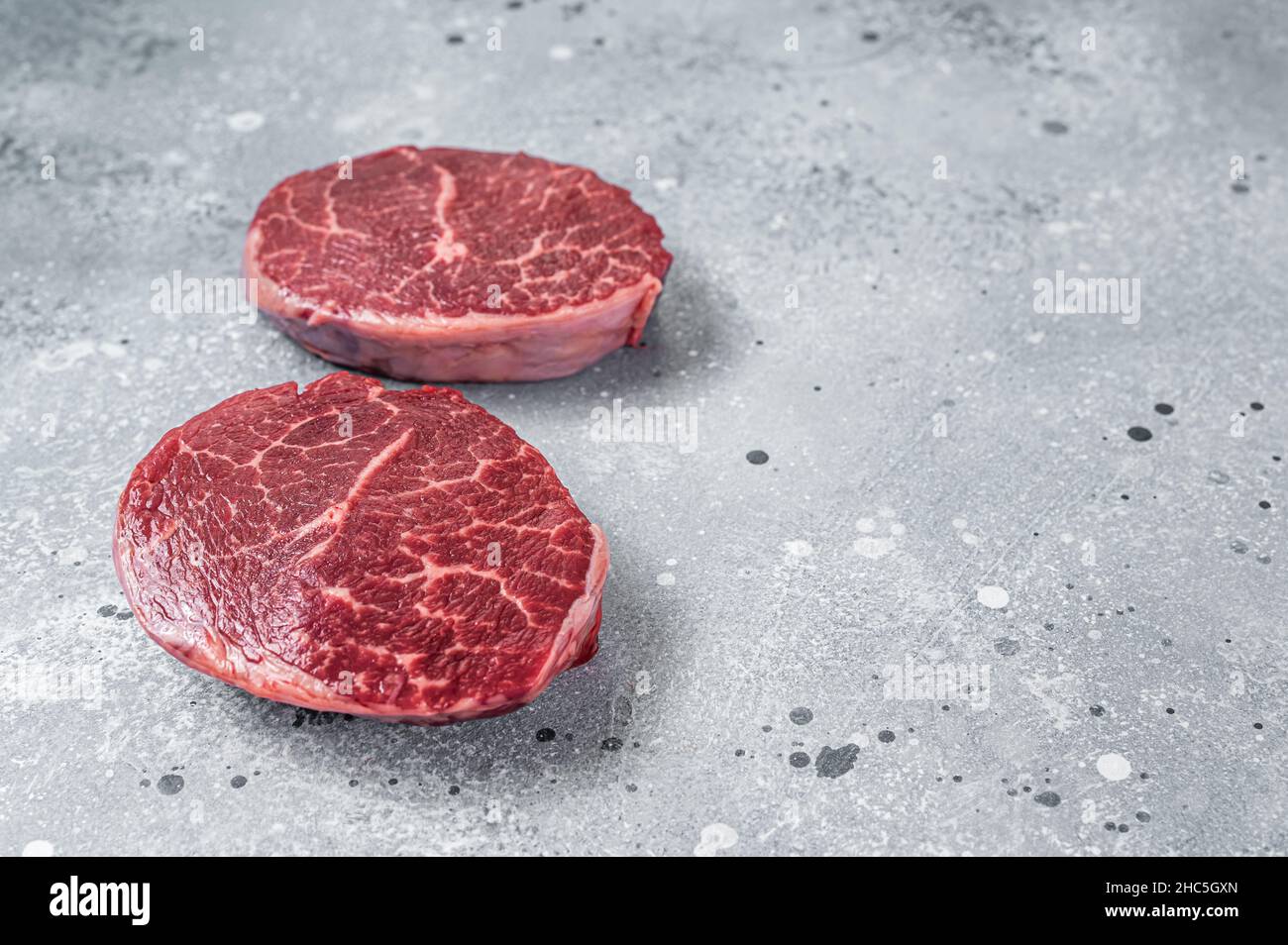 Raw fillet Mignon beef steaks on a butcher board. Gray background. Top ...