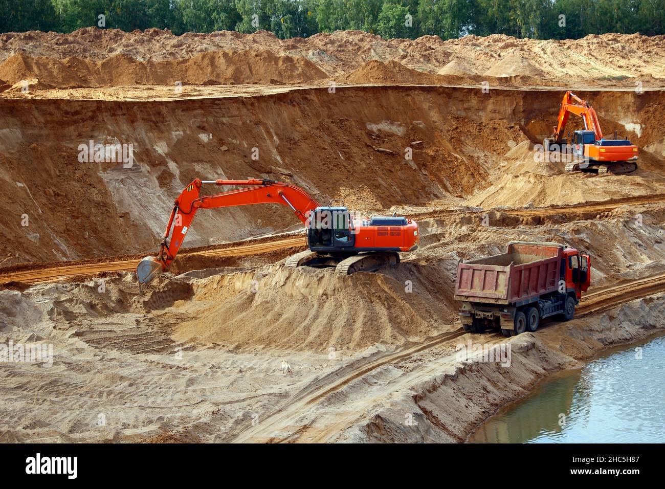 Loading sand into trucks on the sandy career, Mining. Excavators and ...