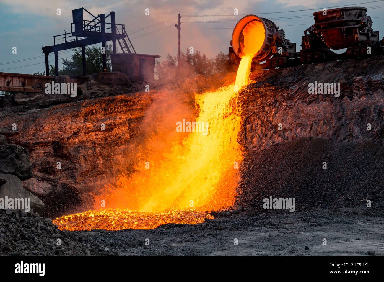 Colorful stream of molten metal at a steel mill. Blast furnace slag at ...