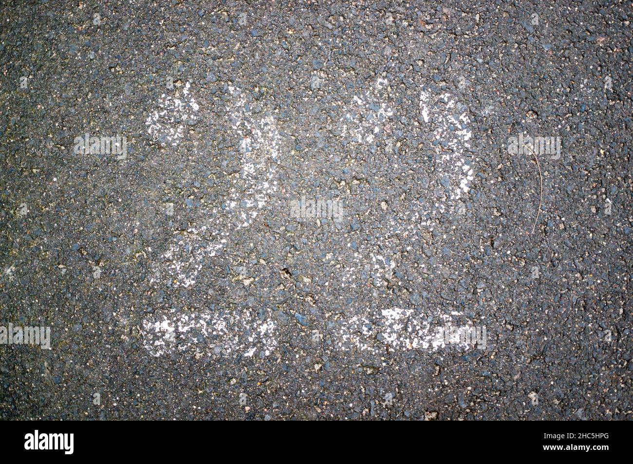 Top view of an erased spray paint 22 number on the ground at the street ...