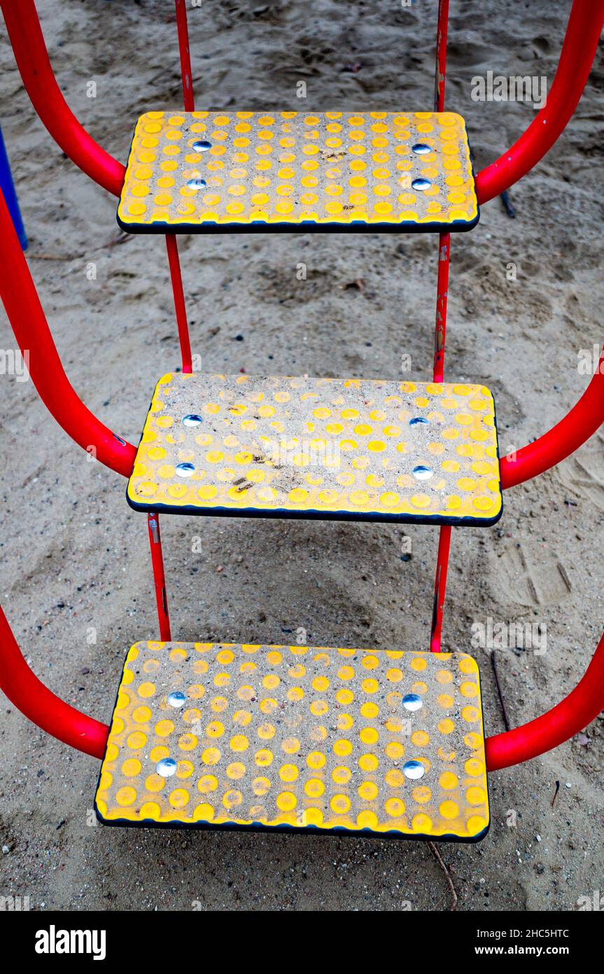 Vertical closeup of old colorful stair steps of the slide in the ...