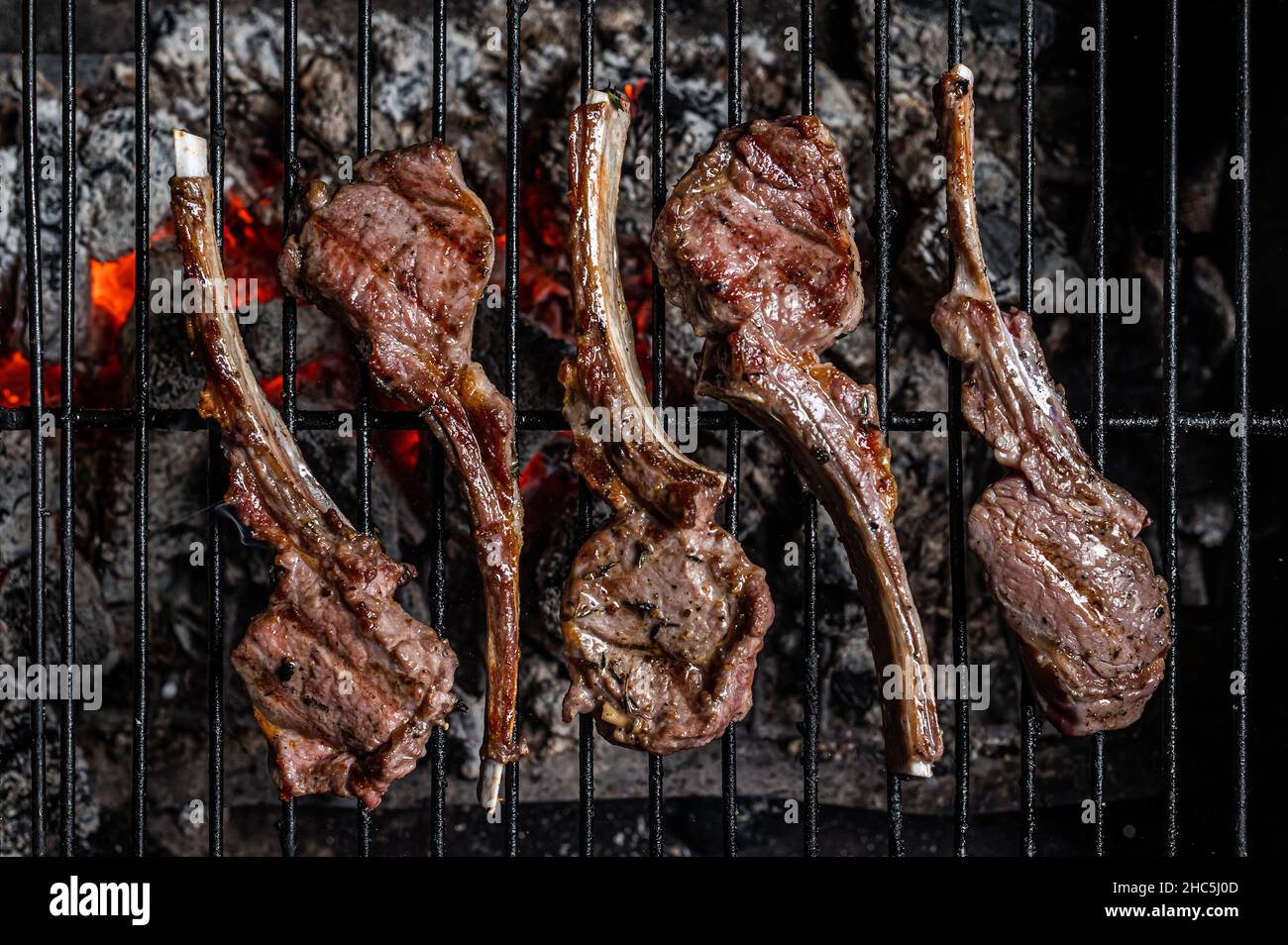 Grilled lamb mutton chop steaks on barbecue, outdoor BBQ grill with ...