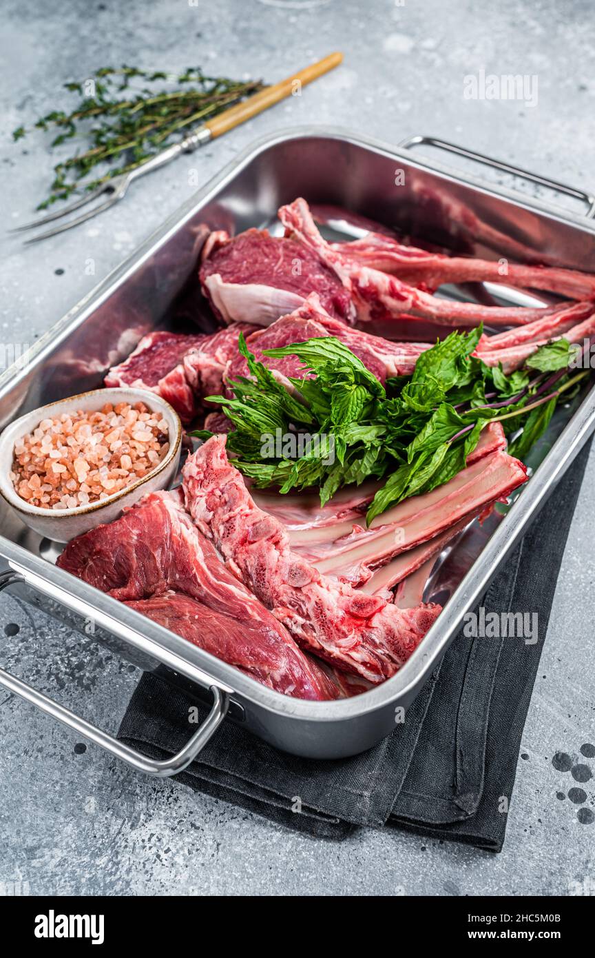 Uncooked Raw lamb, mutton chops in a steel kitchen tray. Gray ...