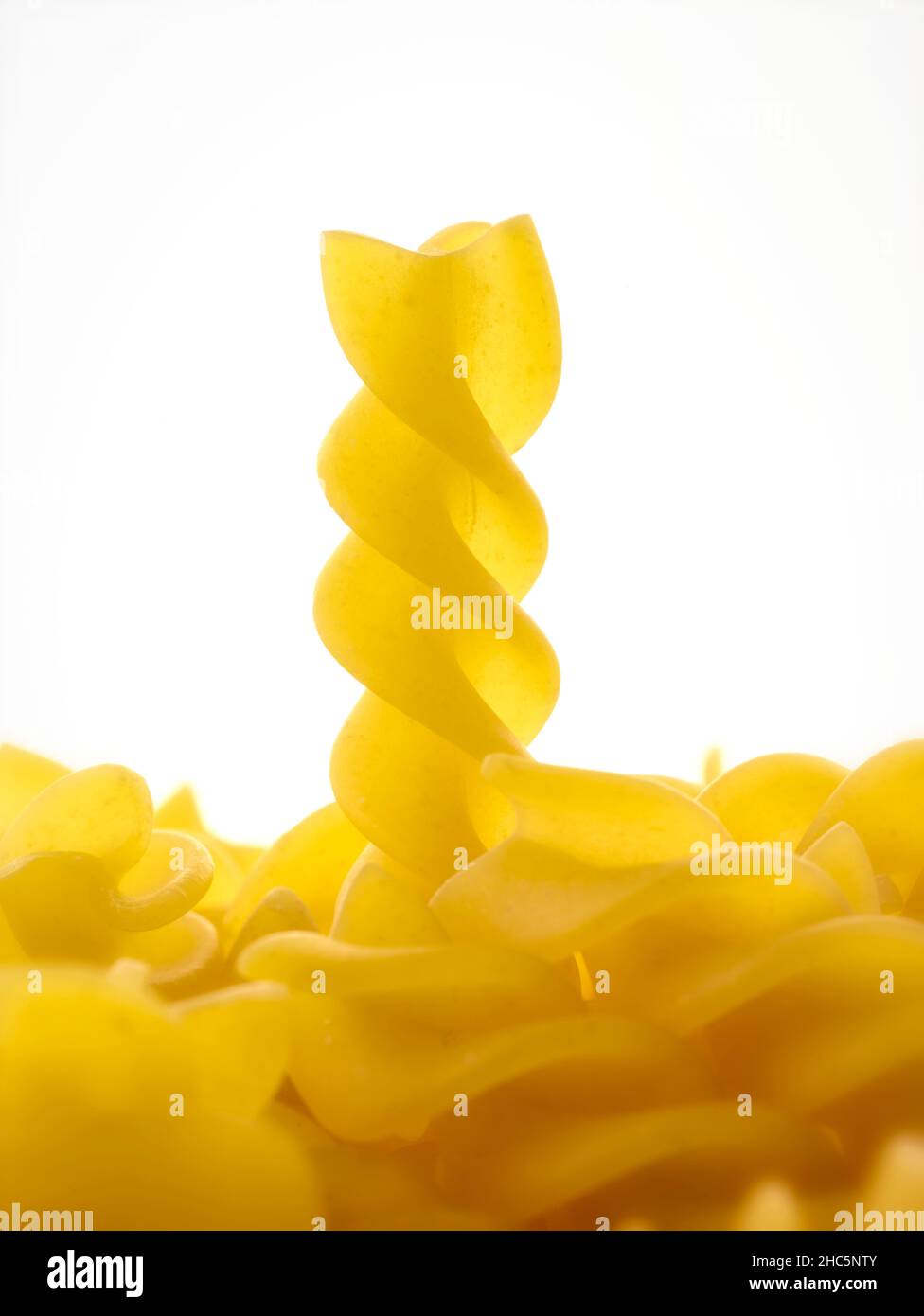 Macro food ingredient of Fusilli, fuˈzilli, pasta, against a plain bac ...