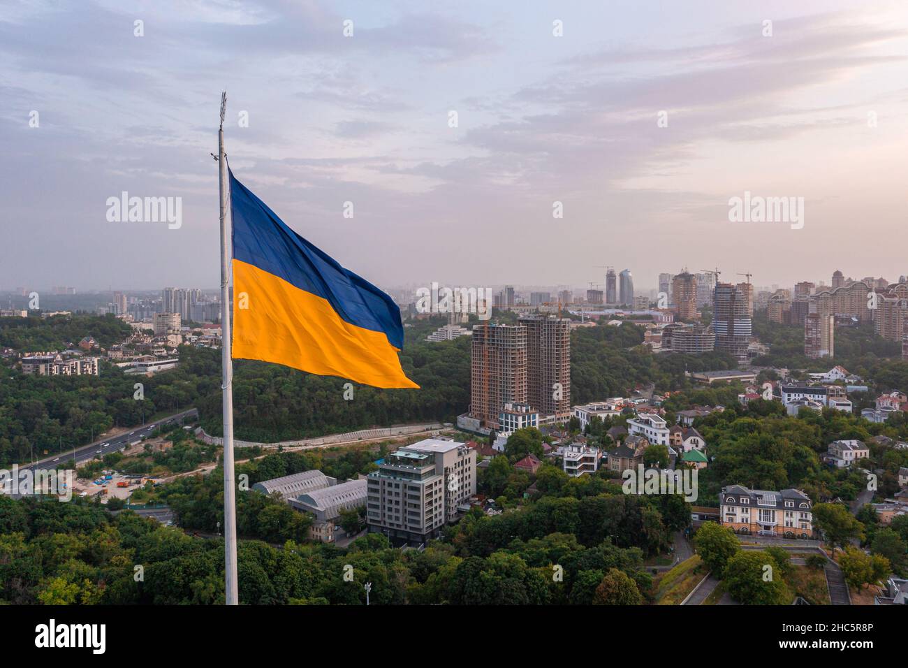 Aerial view of the Ukrainian flag waving in the wind against the city ...