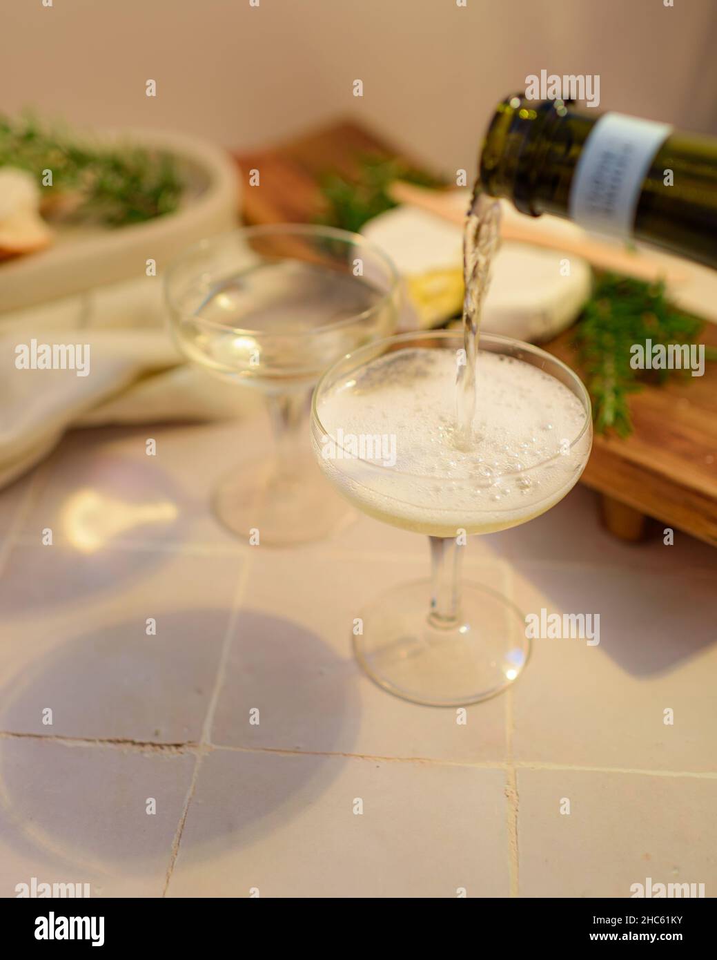 Vertical shot of alcohol being poured into delicate glasses with a ...