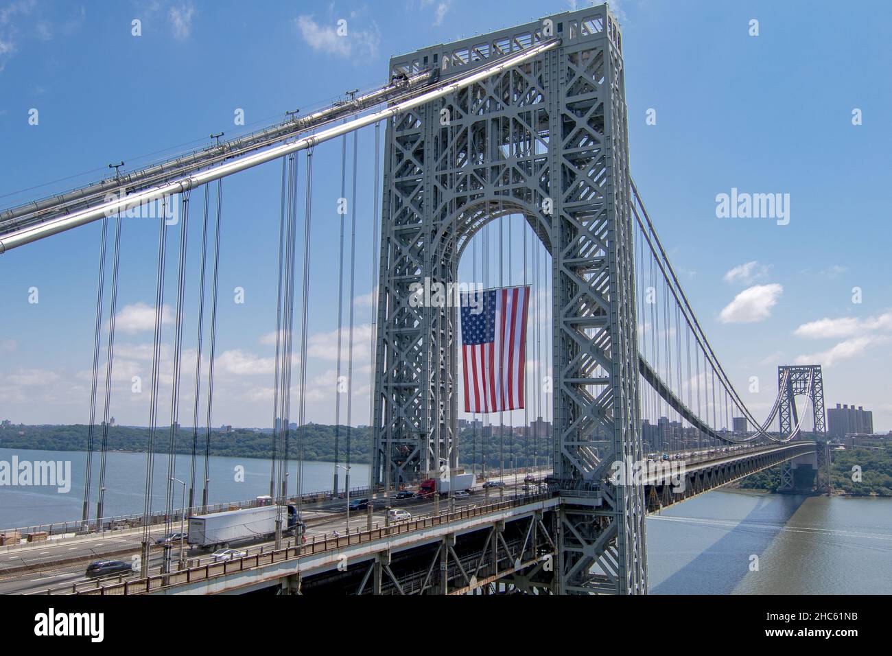 Bright morning at the George Washington Bridge in Fort, USA with the US flag hanging from it ...
