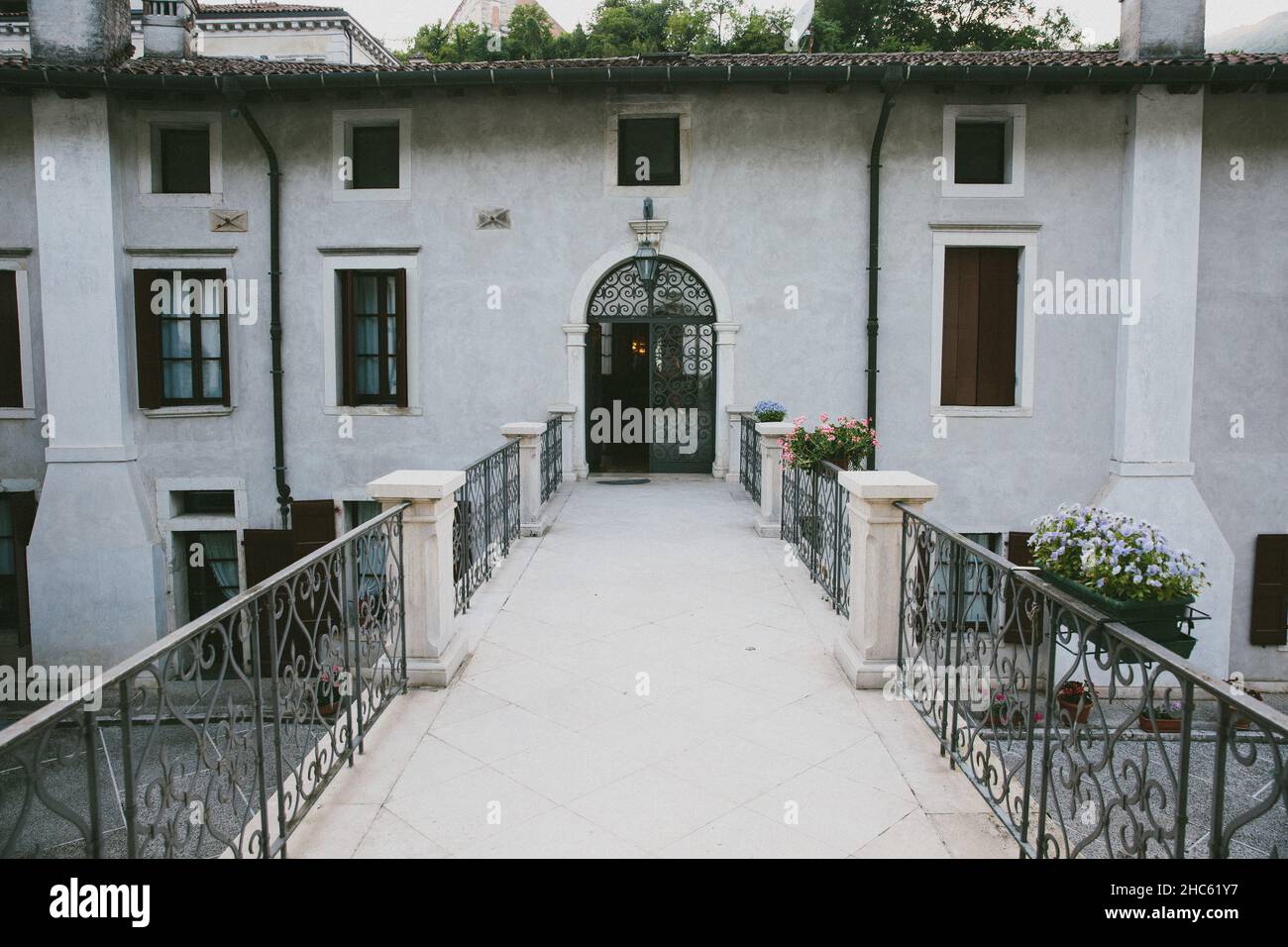 Fenced bridge entrance to a white building Stock Photo - Alamy