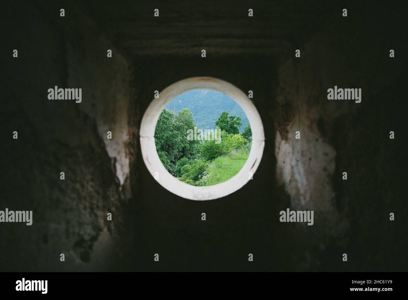 Hole-window with the view of trees on mountains from a grungy old ...