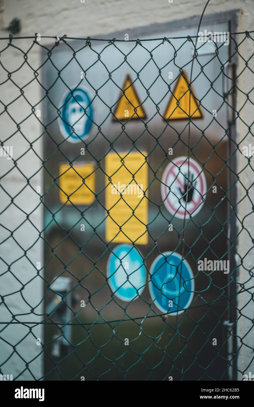 Vertical shot of a chain-link fence in front of a door with multiple ...