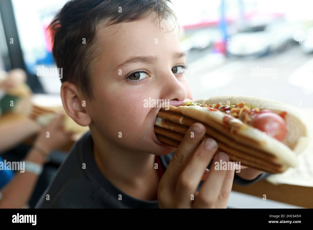 Portrait of kid eating Hot Dog in restaurant Stock Photo - Alamy