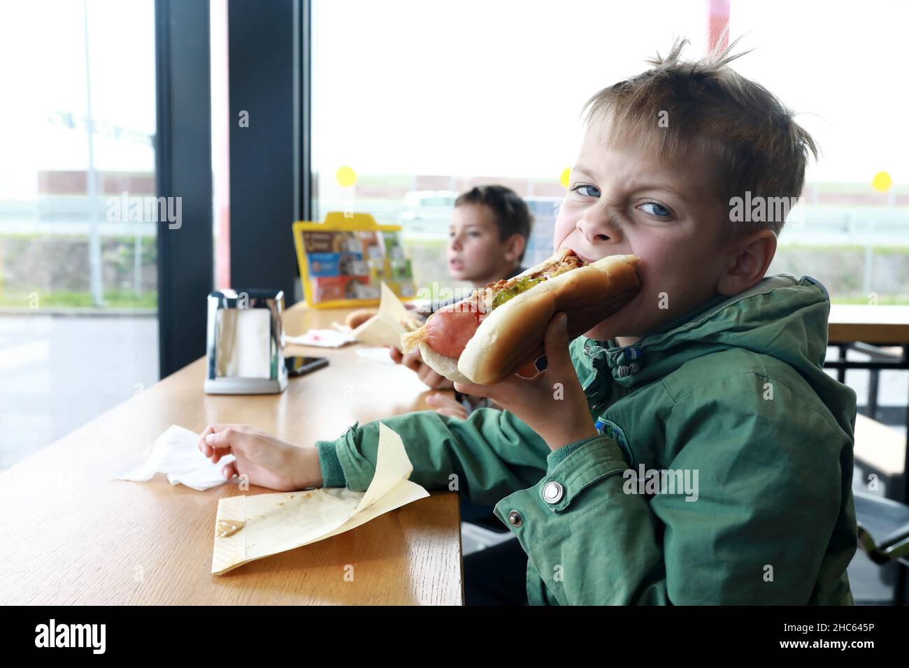 Portrait of child eating Hot Dog in restaurant Stock Photo - Alamy