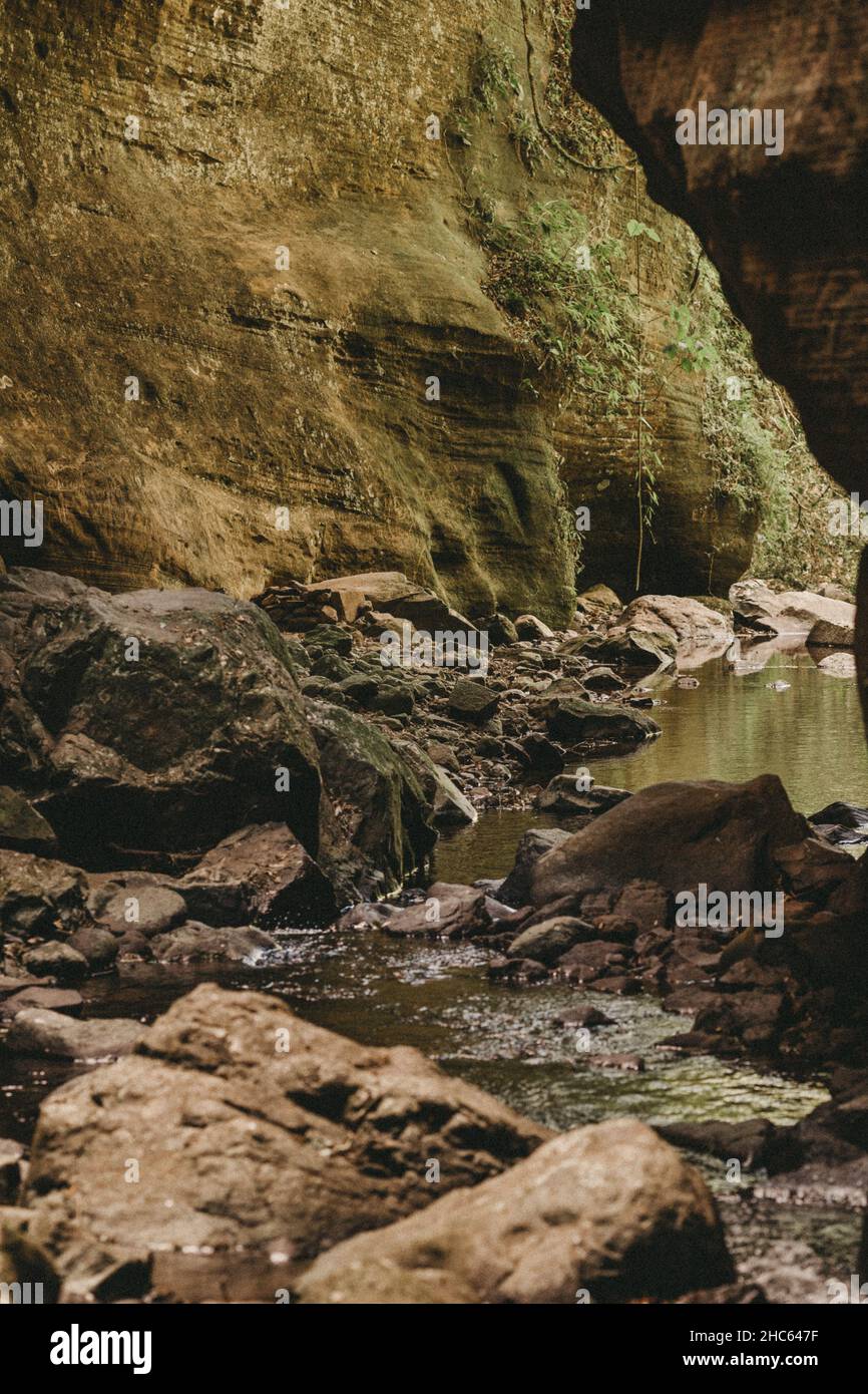 Vertical shot of a wild river flowing through the rocks in a cave Stock ...