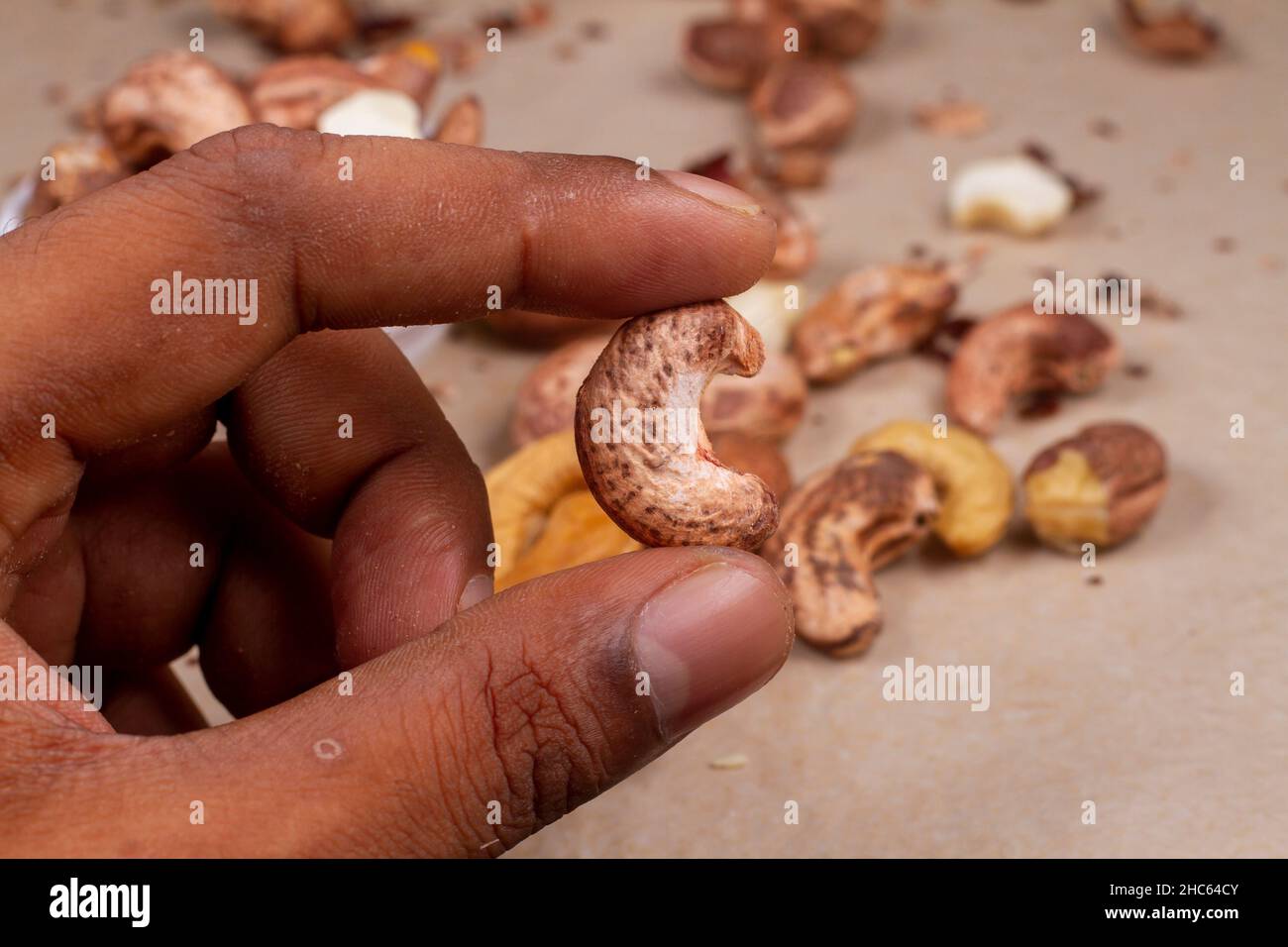 Roasted cashew nuts in hand on light background isolation Stock Photo ...