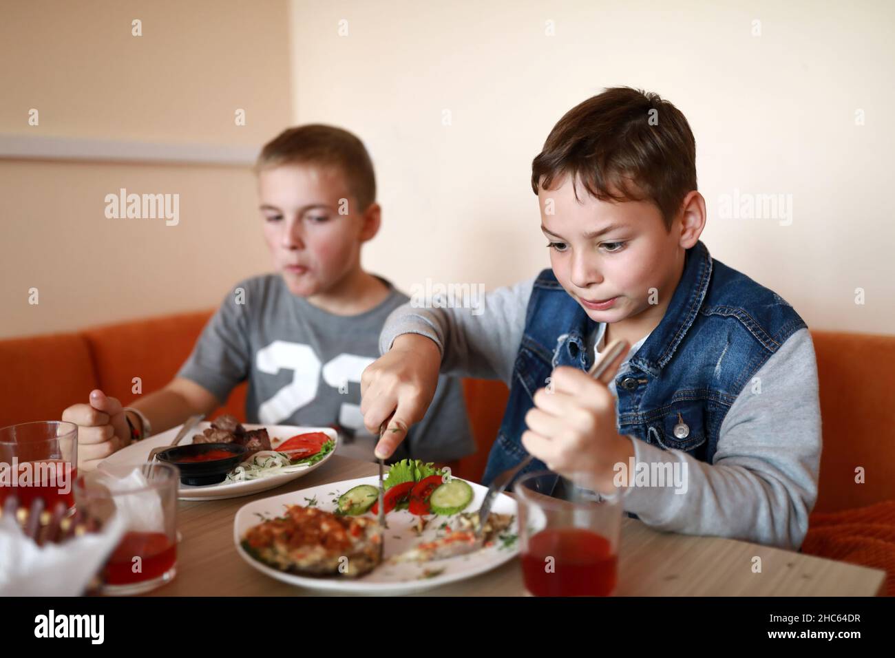 Portrait of two kids have lunch in restaurant Stock Photo - Alamy