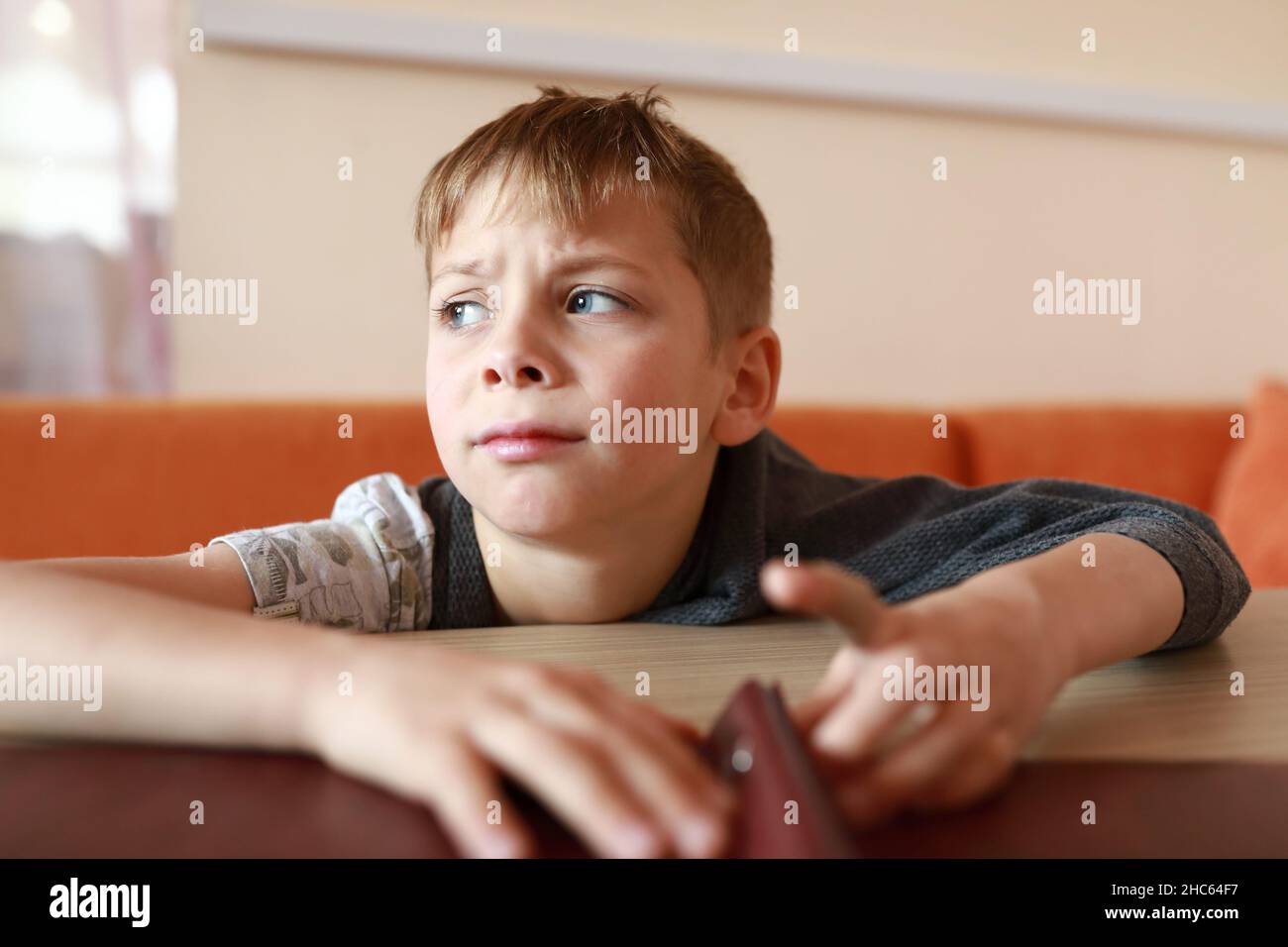 Upset hungry child waiting food in restaurant Stock Photo - Alamy