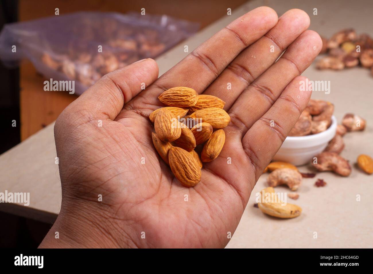 Roasted almonds nuts in hand on light background isolation Stock Photo ...