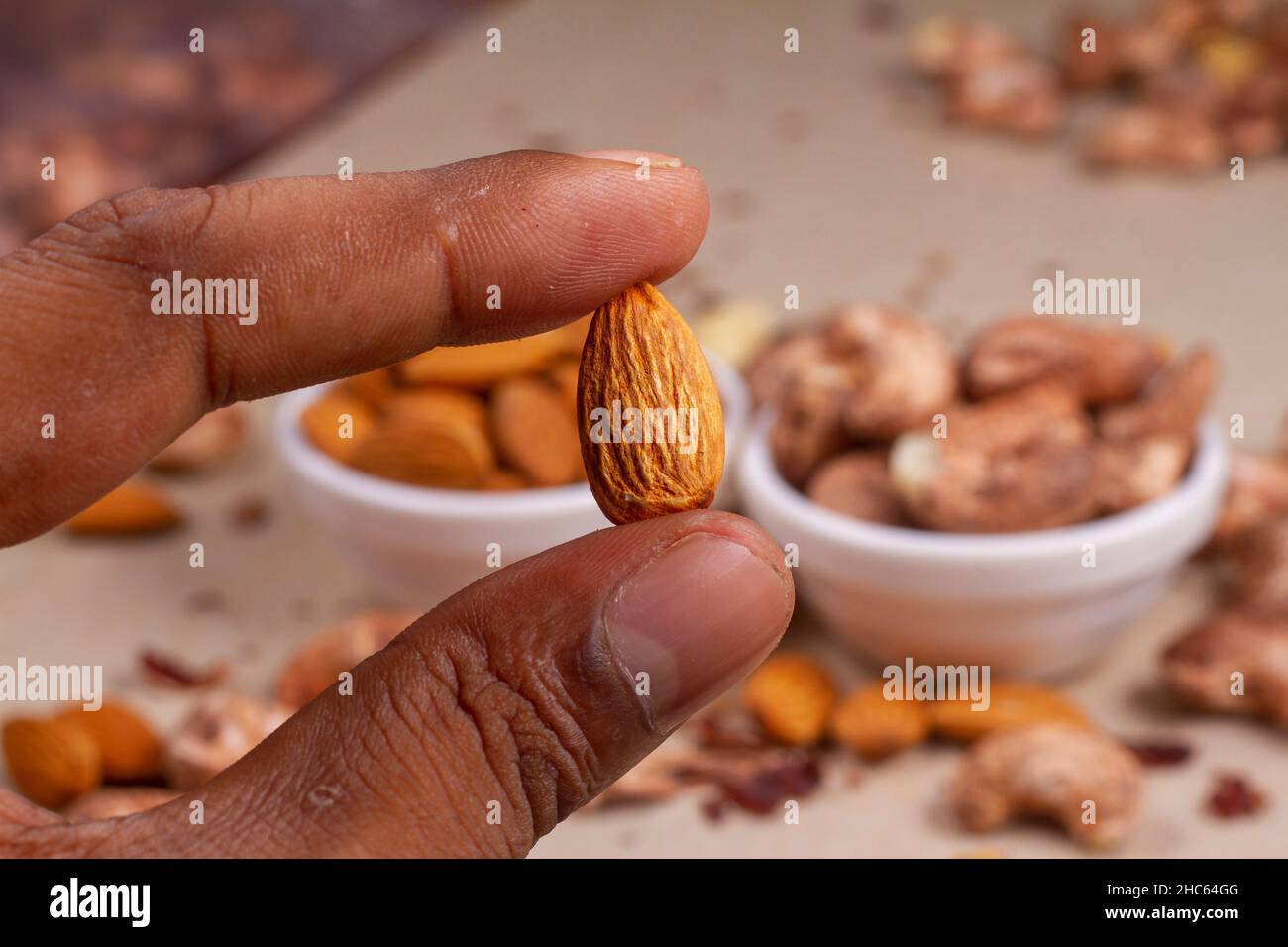 Roasted almonds nuts in hand on light background isolation Stock Photo ...