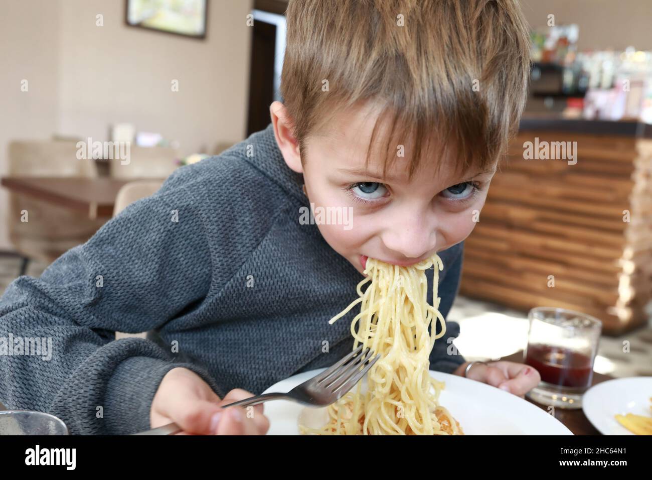 Kid eating nuggets with pasta in restaurant Stock Photo - Alamy