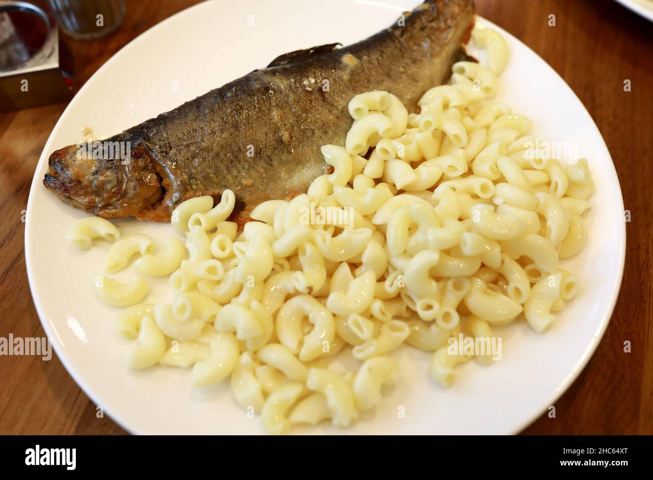 Fried Trout with macaroni on plate in restaurant Stock Photo - Alamy