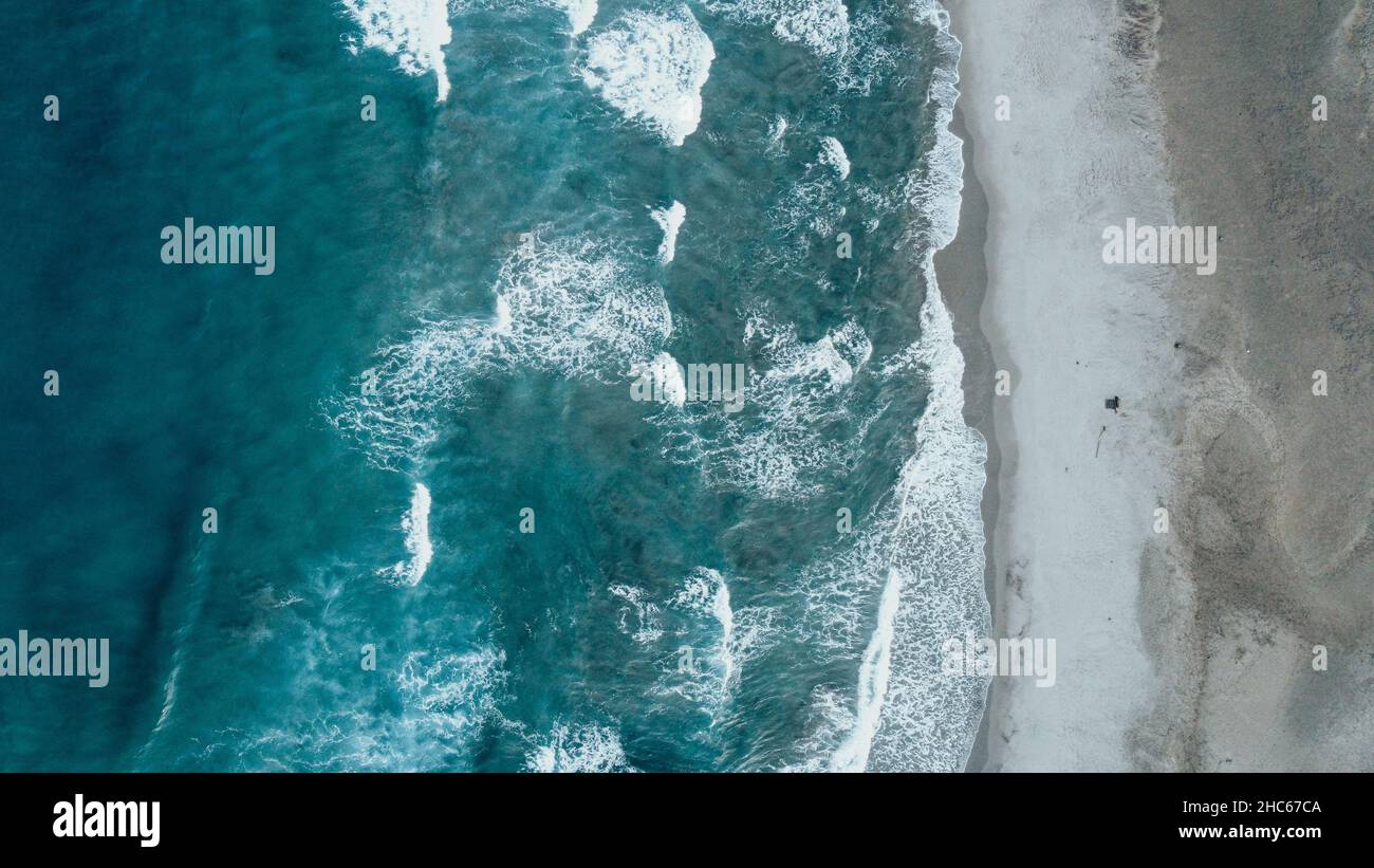 Overhead shot of a wavy ocean and a sandy beach - perfect for ...