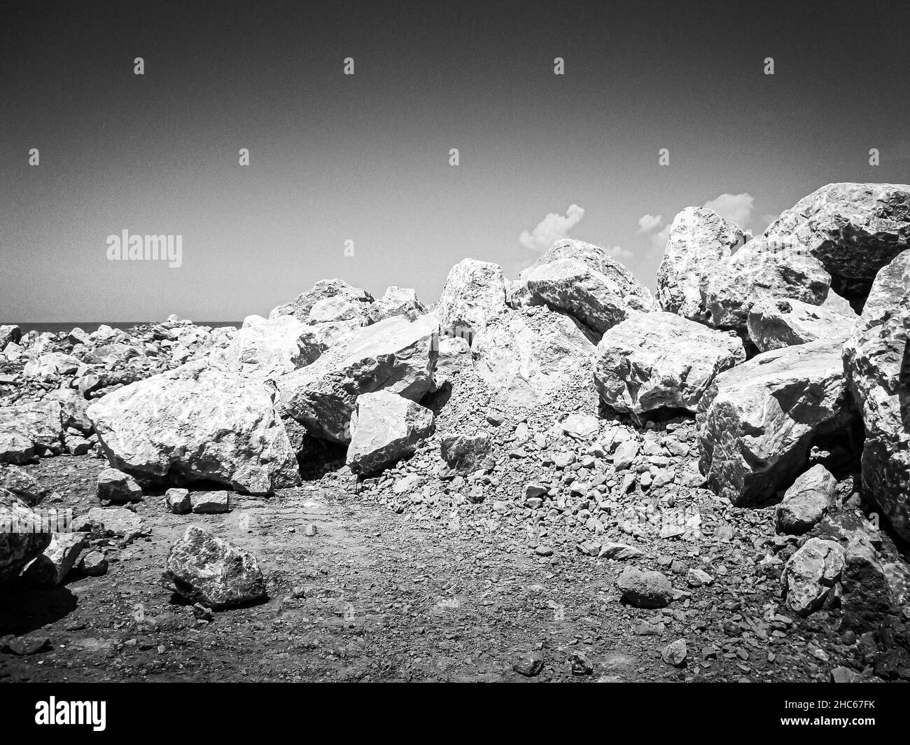 Grayscale shot of big rocks scattered in the deserted area Stock Photo ...
