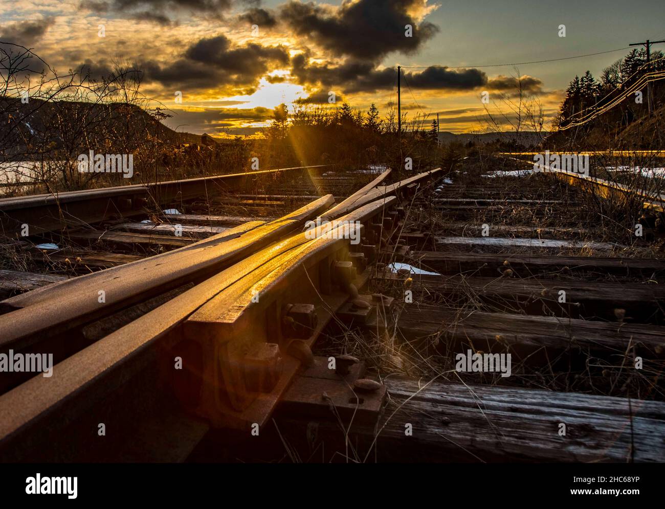 Low angle shot of rails during the sunrise under the cloudy skies Stock ...