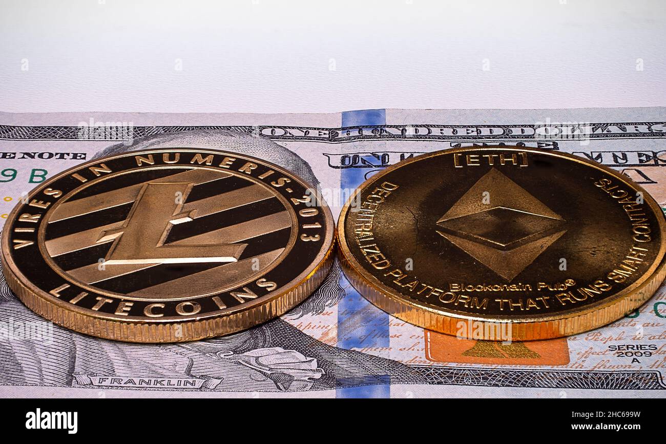 Closeup of Crypto coins LTC and ETH on 100 US dollar on isolated white ...