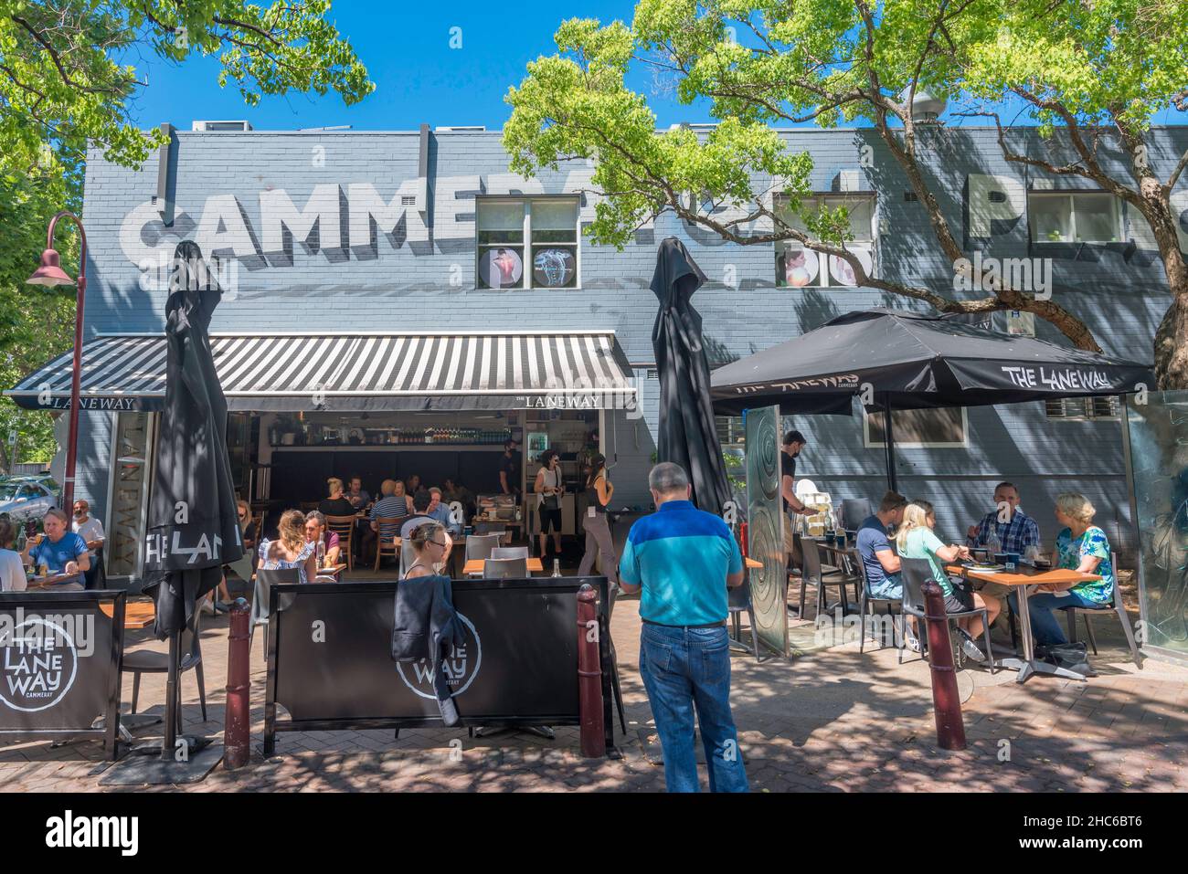 People sitting or standing separated outside a cafe, coffee shop in the ...
