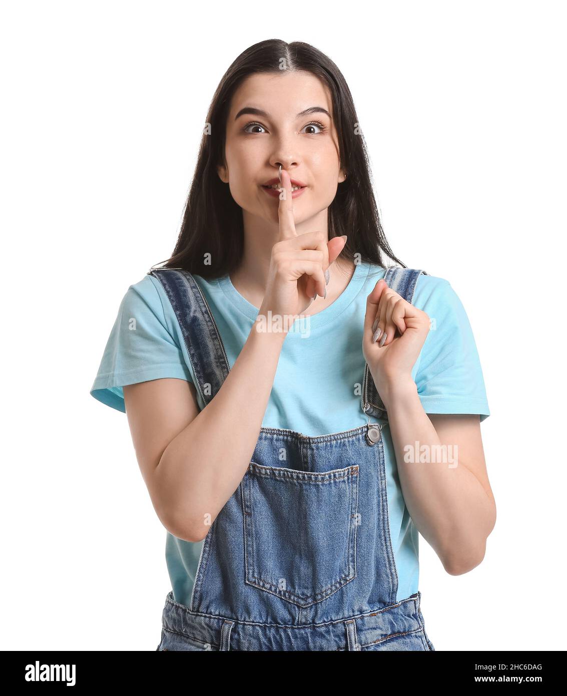 Young woman showing silence gesture on white background Stock Photo - Alamy