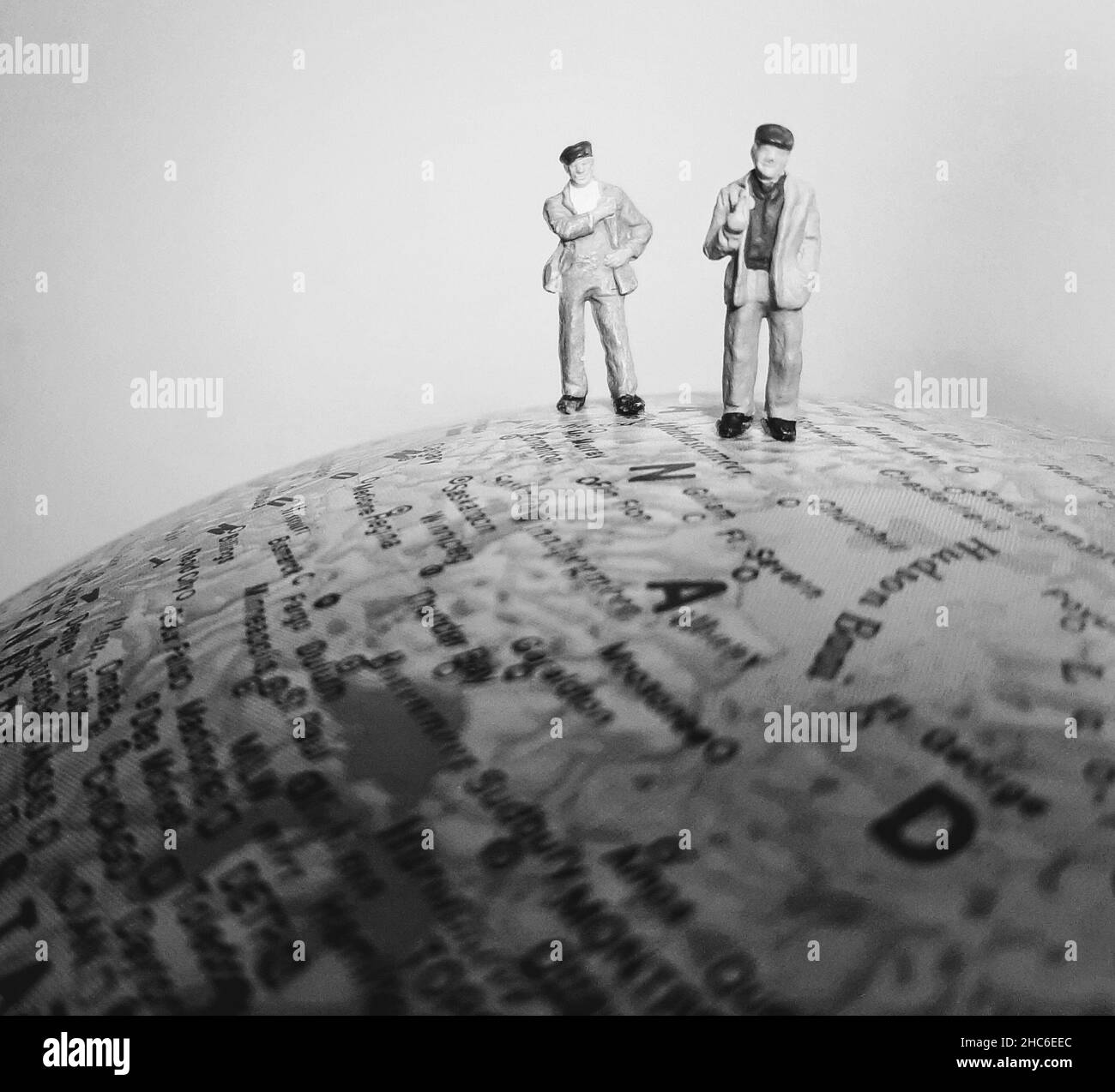 Grayscale of two human figures on the globe map Stock Photo - Alamy