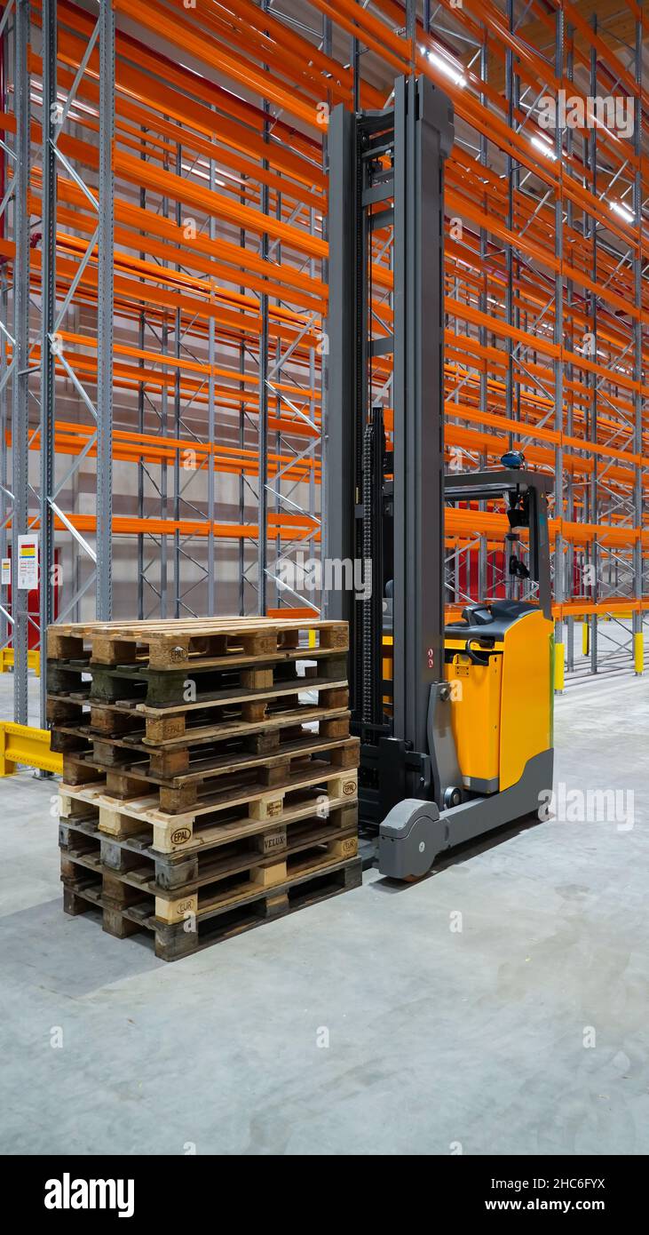 Forklift with pallets in a logistics warehouse Stock Photo - Alamy