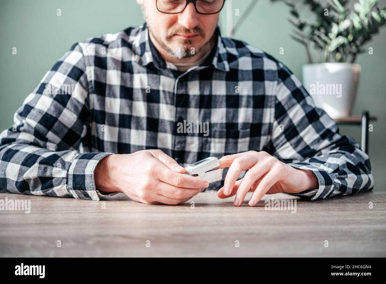 A man checking oxygen level at home with home oximeter, patient ...