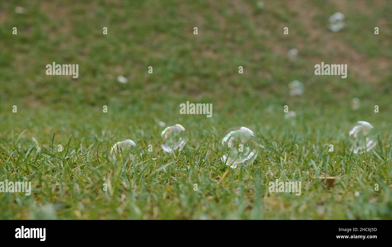 Happy smiling girl playing with giant soap bubbles. Female child ...