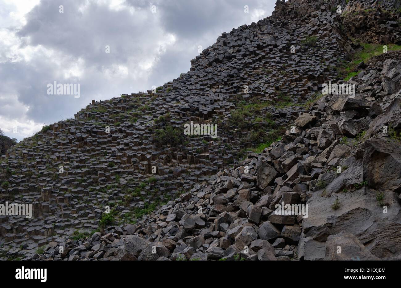 A steep of rocks and geometrical shape stones with rainy clouds in the ...