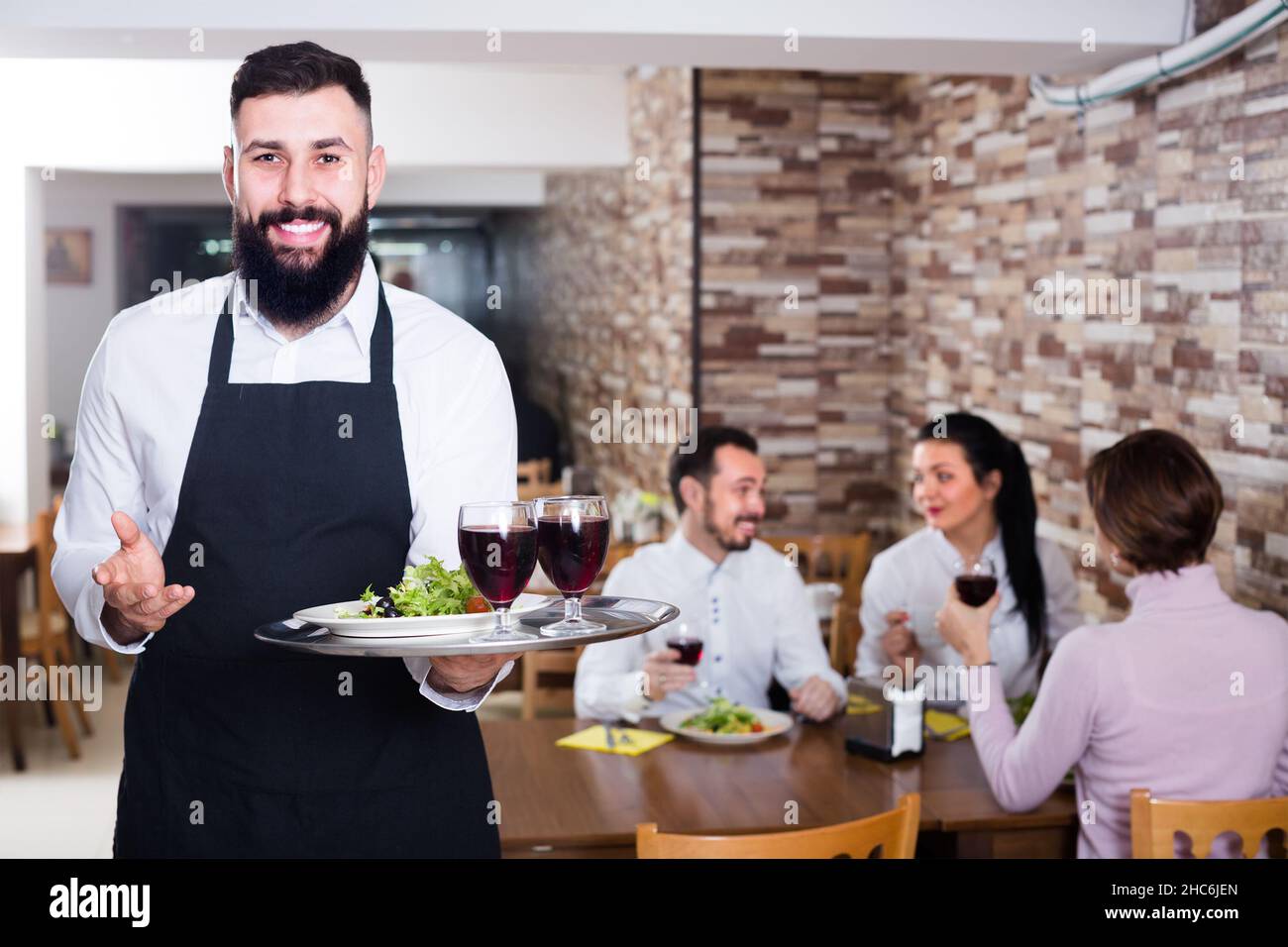 happy waiter serving dear restaurant guests Stock Photo - Alamy