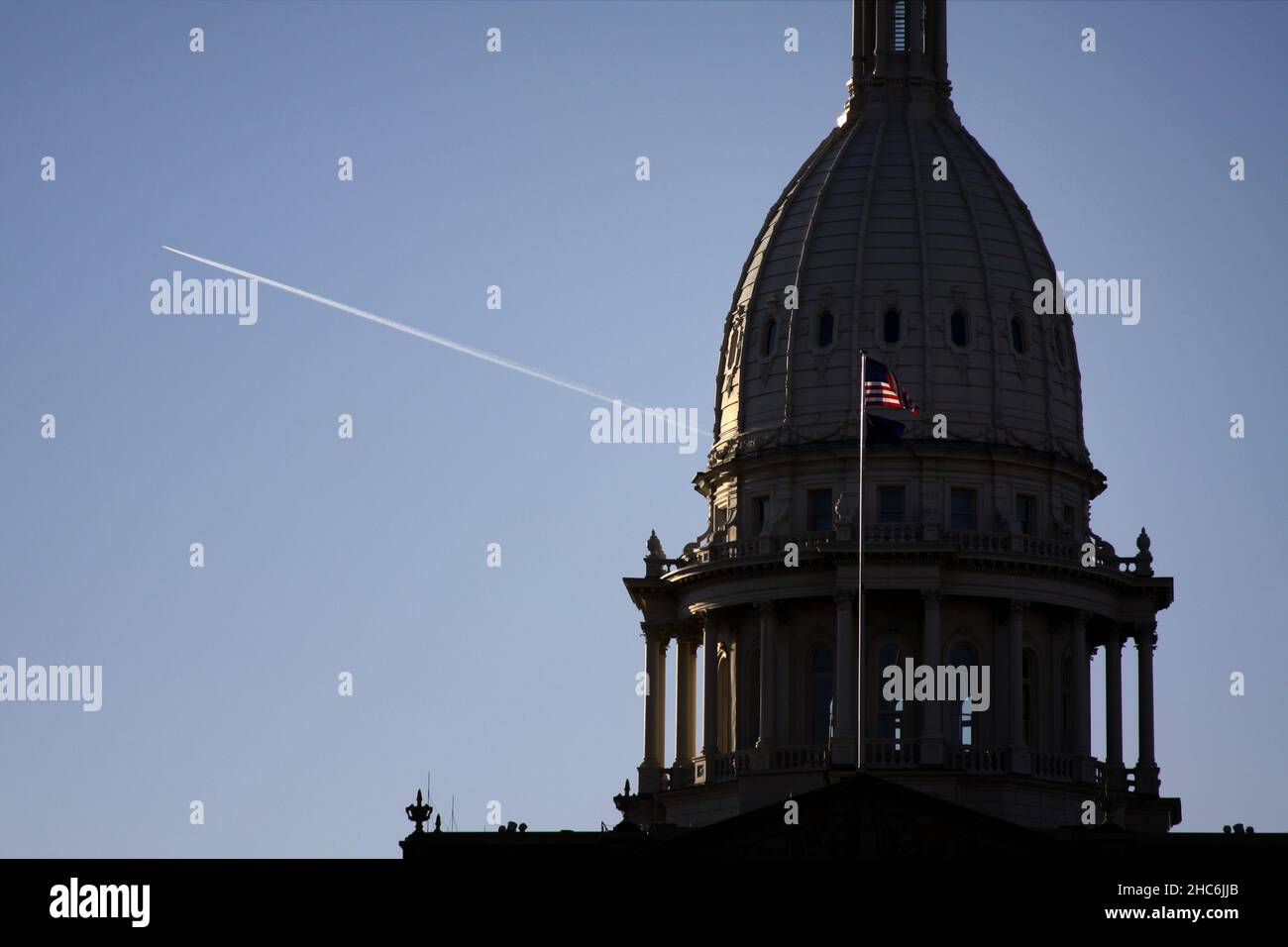 The Michigan State Capitol building, flying the American Flag, with an ...