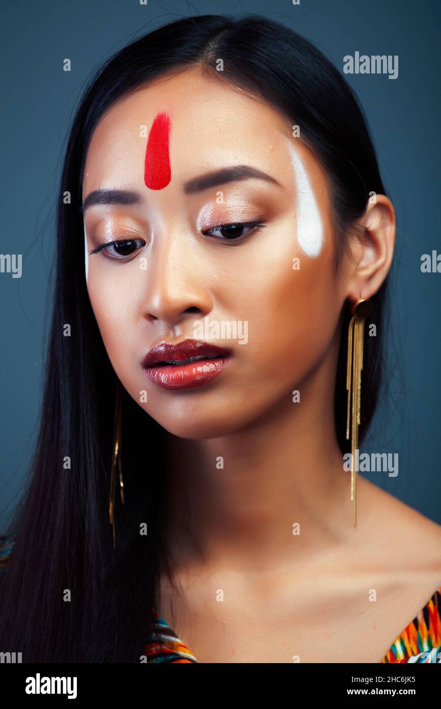 young pretty south asian girl posing in studio on grey background ...